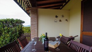 Uma mesa de madeira com duas taças de vinho, uma garrafa de vinho e um prato de morangos.