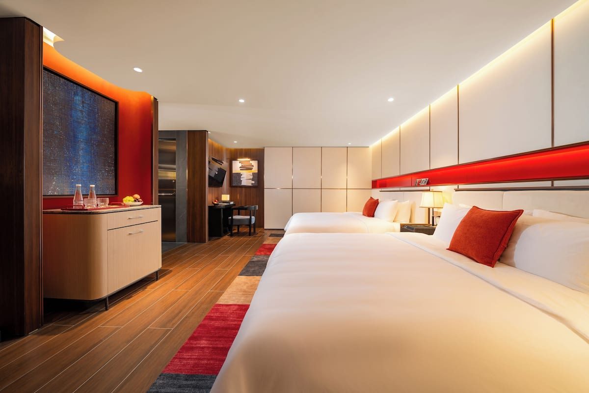 Quarto de hotel com uma cama grande, uma escrivaninha e um espaço de estar.