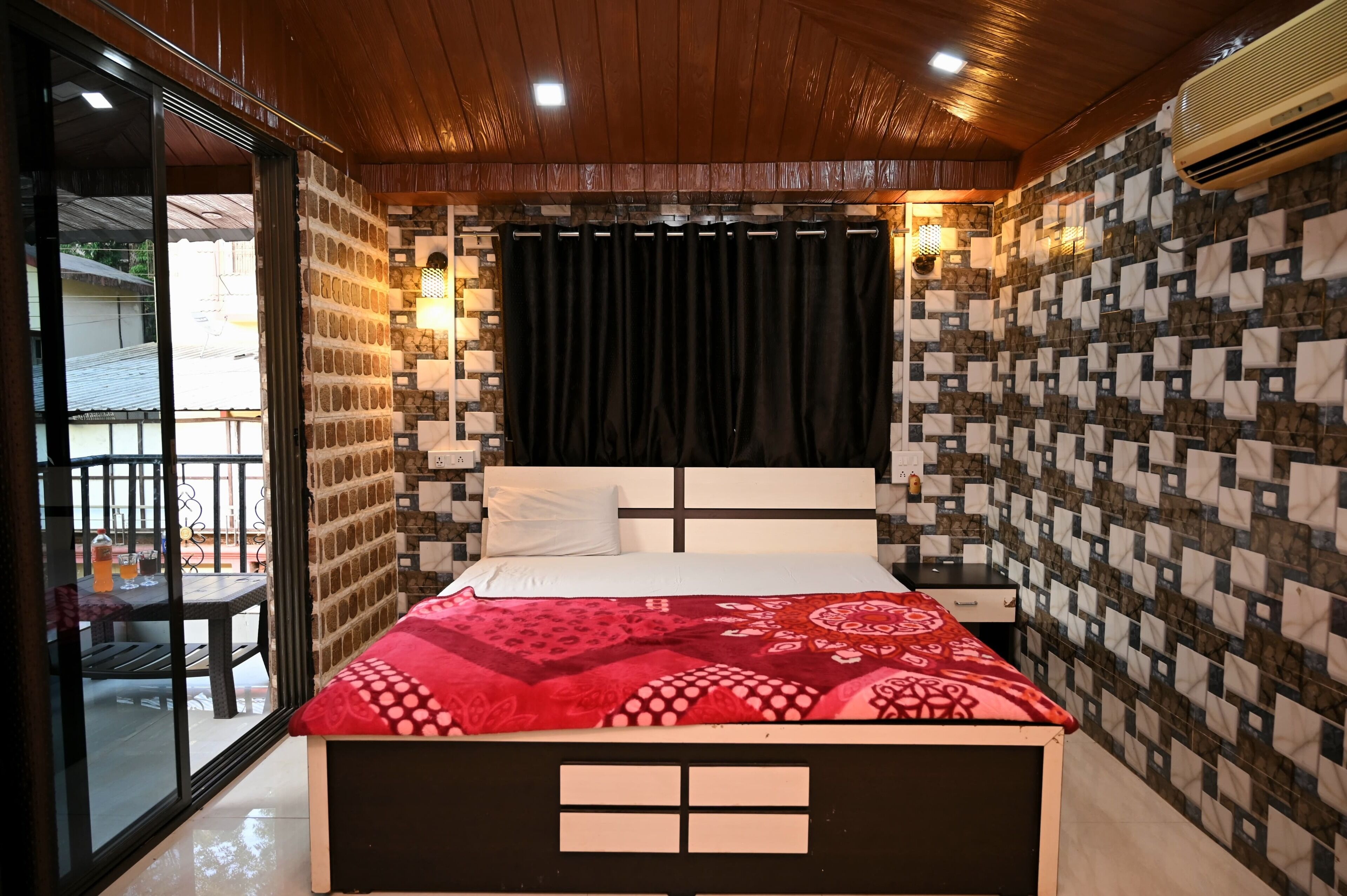 Quarto com cama, janela e parede com um desenho estampado.