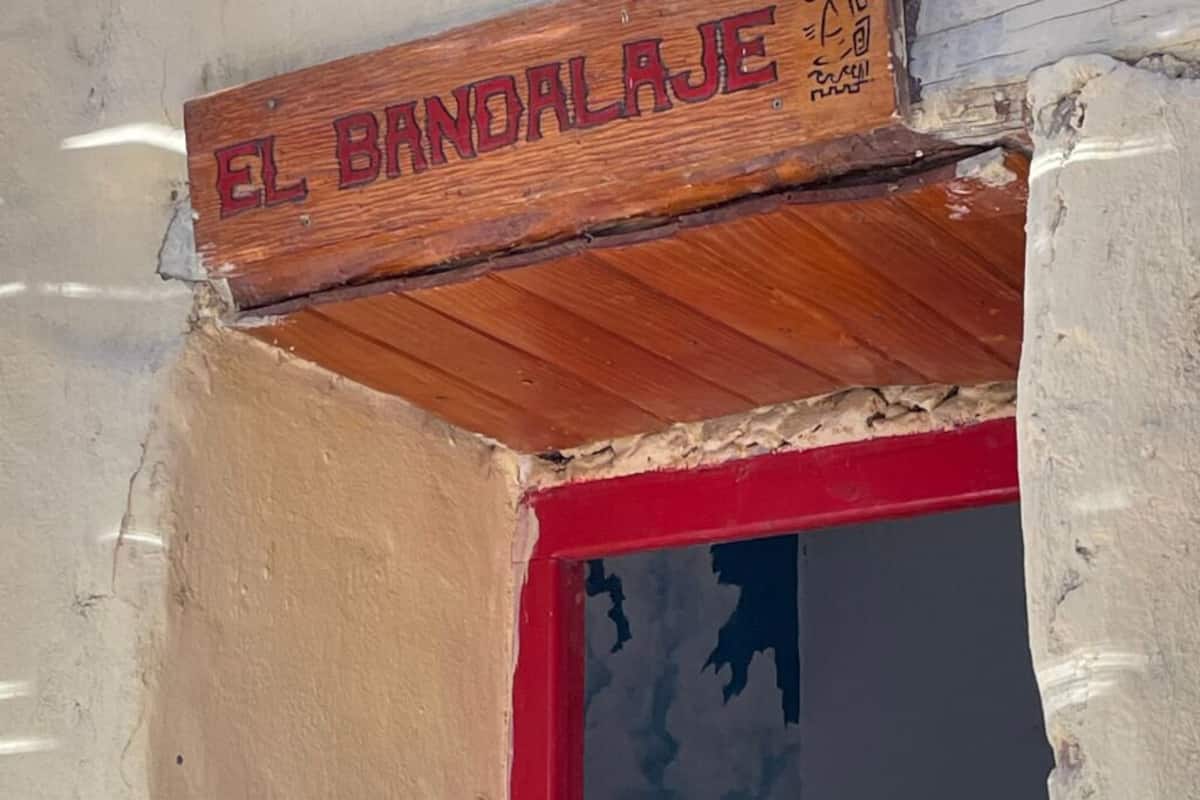 Uma placa de madeira com o texto 'EL BANDALJE' em língua estrangeira, indicando um local ou estabelecimento.