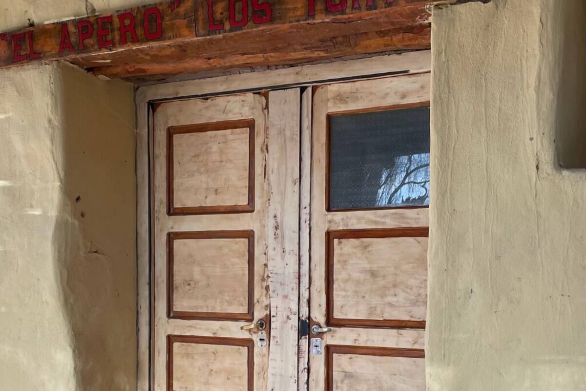 Uma porta de madeira com uma placa acima que diz "EL APERO LOS TORTOLOS".