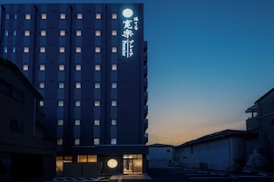 Um edifício de hotel com vários andares e um letreiro iluminado em destaque.