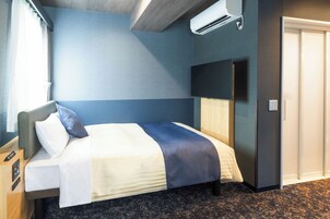 Quarto de hotel com cama, televisão de tela plana, ar condicionado e porta.