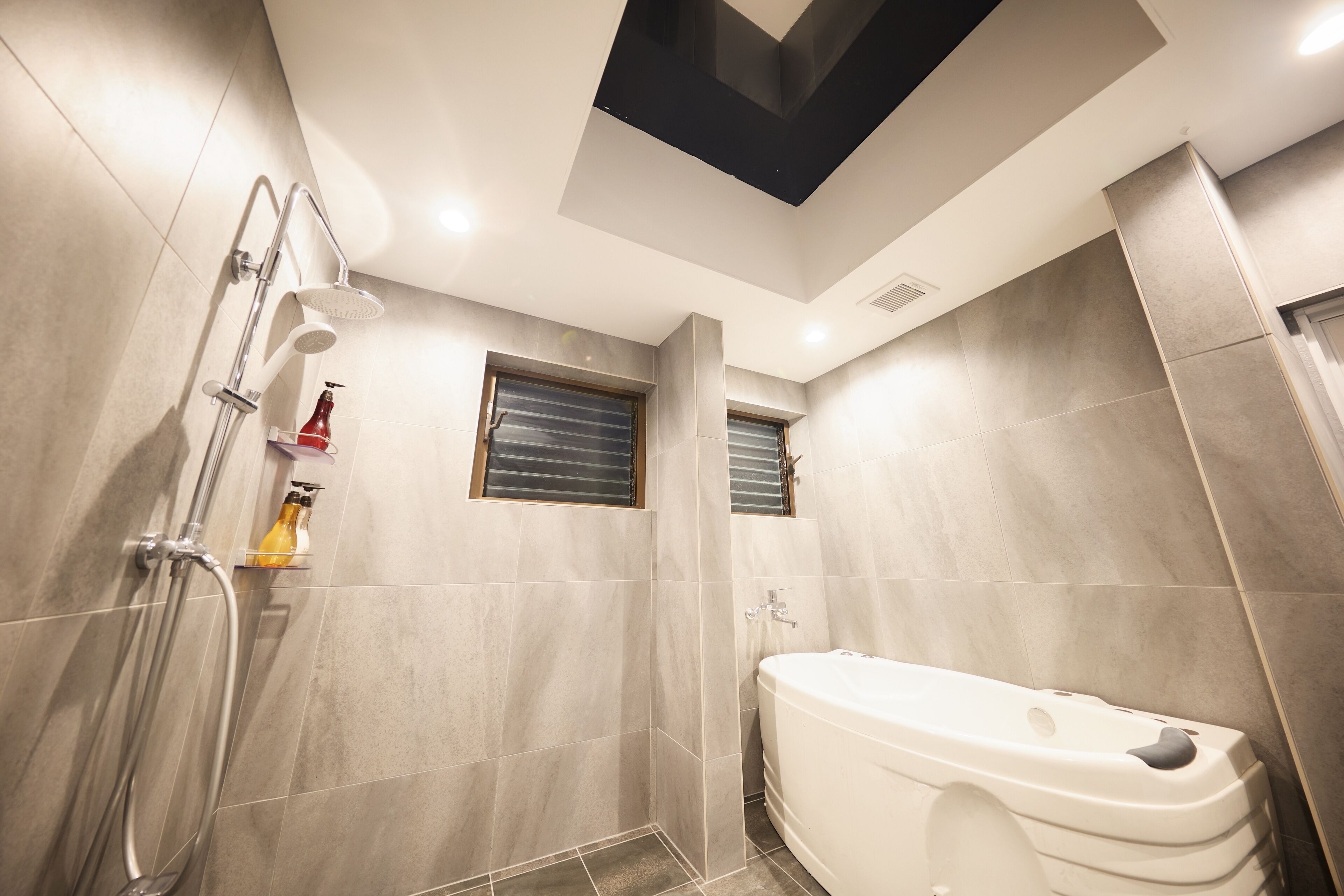 Uma casa de banho moderna com chuveiro amplo, banheira e janela.