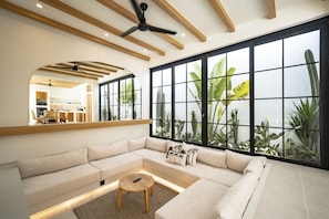 Villa Deluxe, 2 quartos, pátio, vista para a piscina | Sala | Televisor de 50 polegadas com canais por cabo 