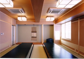 Quarto com esteiras de tatame, um biombos shoji e uma mesa de tatame.