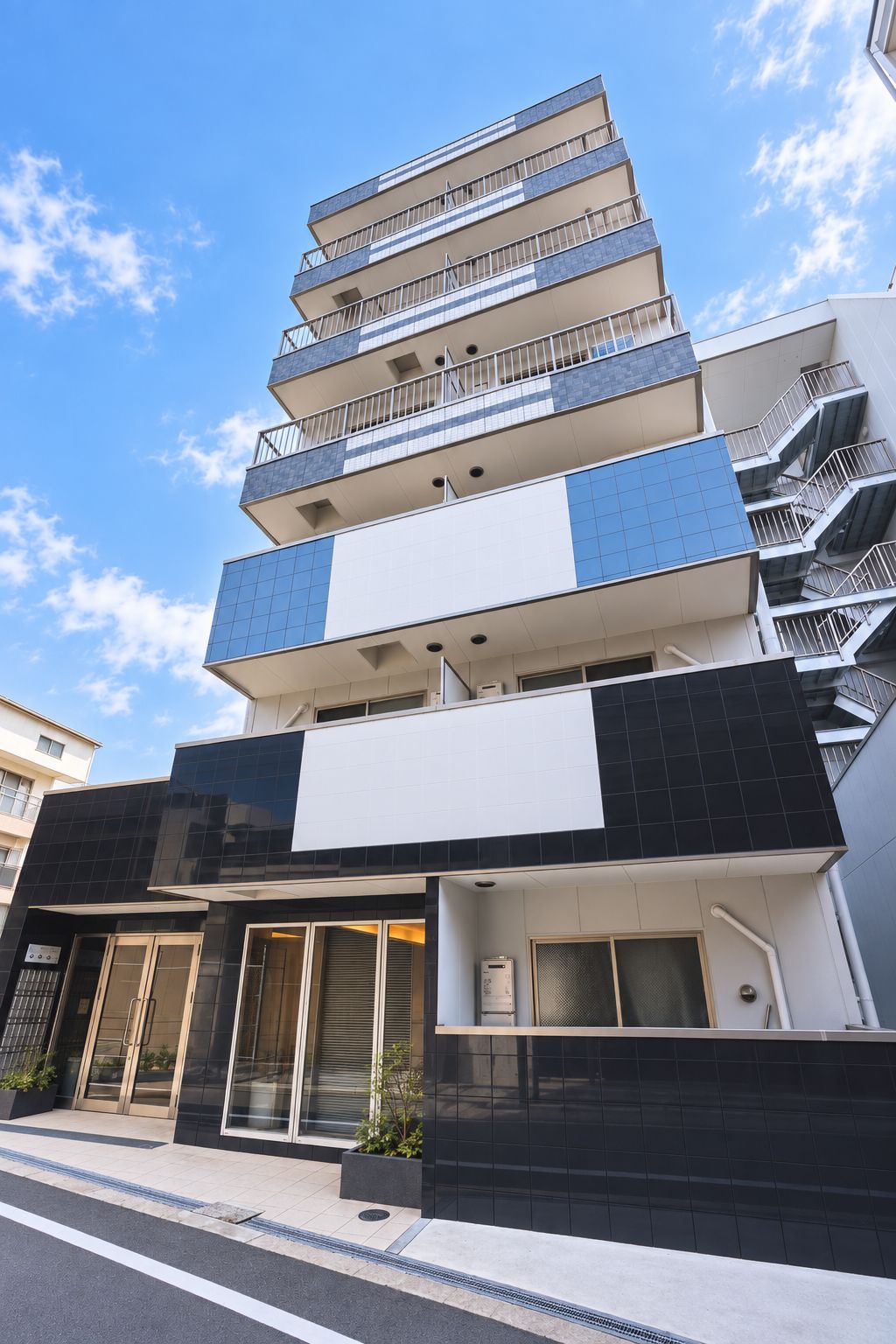 Um edifício de vários andares com design arquitetônico moderno, com varandas, janelas amplas e telhado plano.
