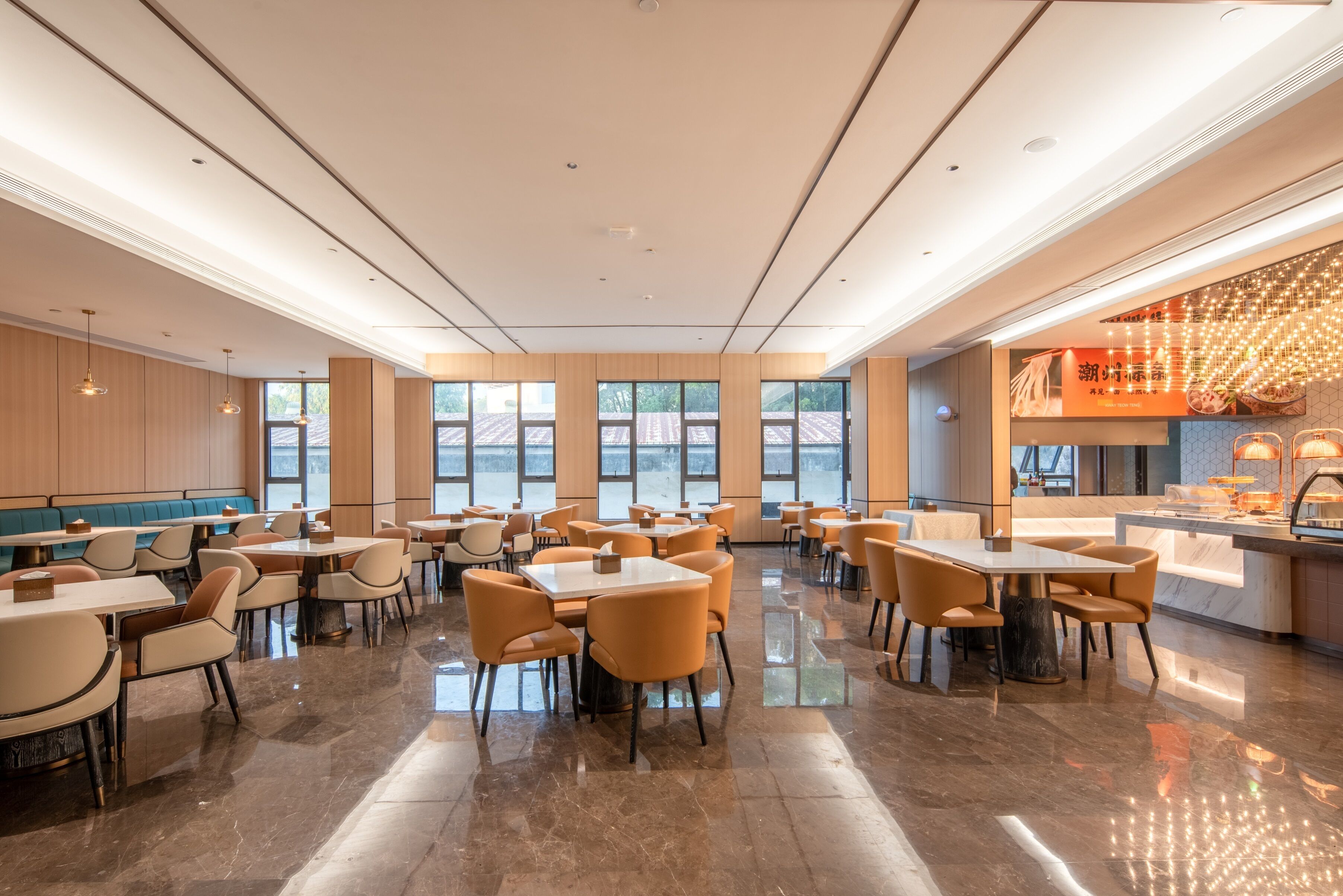 Um restaurante espaçoso com várias mesas e cadeiras, grandes janelas e design de interiores moderno.