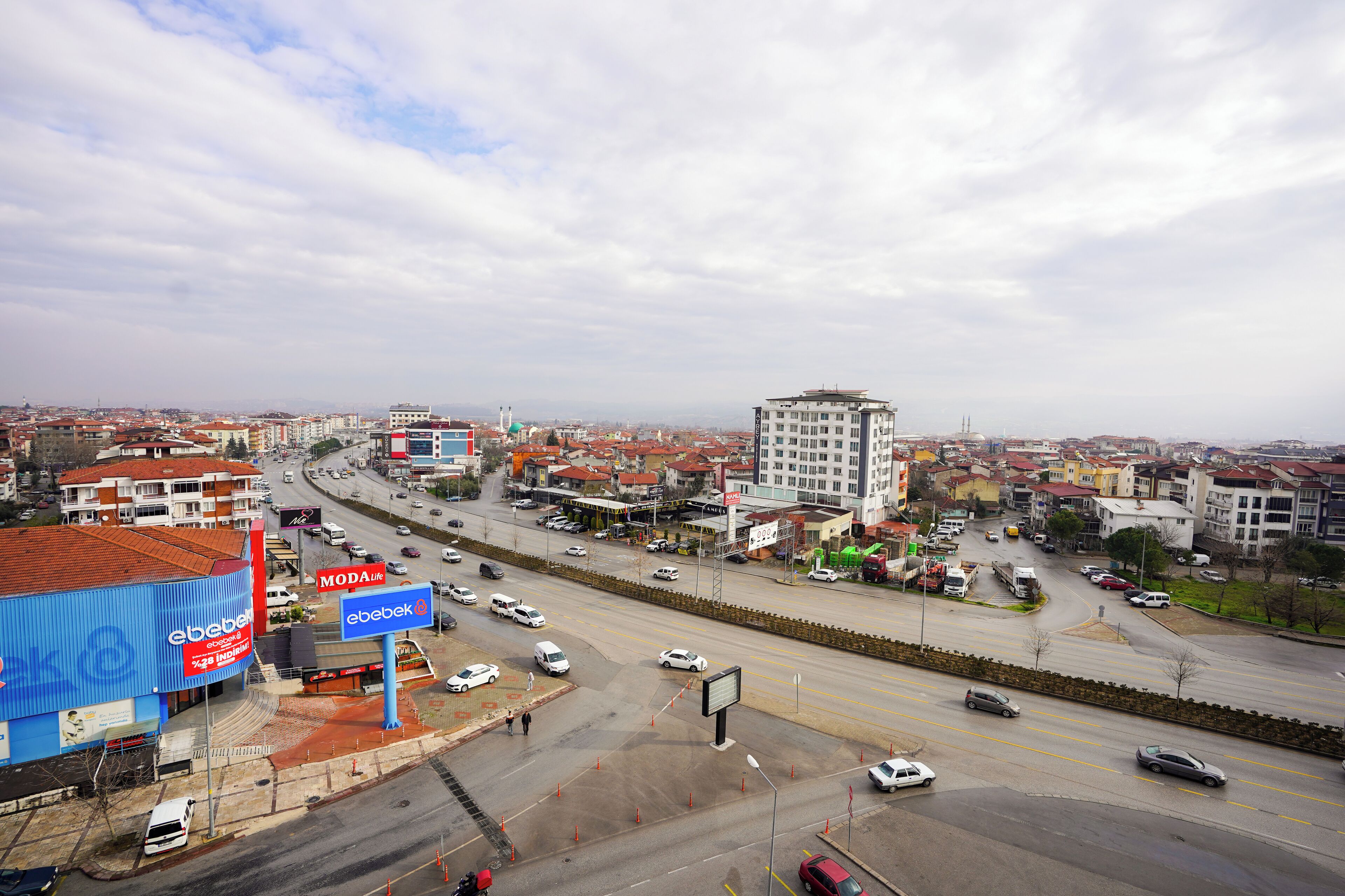 Paisagem urbana com um shopping center destacado e uma rodovia.