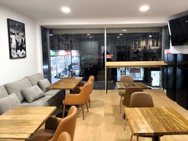 Um interior moderno com um sofá, mesas de madeira e cadeiras.