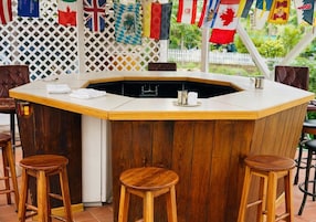 Uma área de bar com balcão de madeira e banquetas.