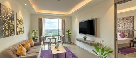 Uma sala de estar moderna com sofá, mesa de centro, televisão e plantas.