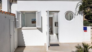 Uma casa moderna com duas portas abertas que dão para uma sala de estar e uma cozinha.