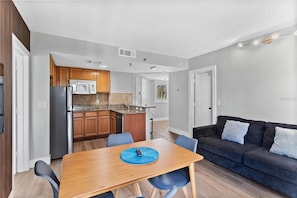 Um apartamento moderno com cozinha, sala de jantar e sala de estar.