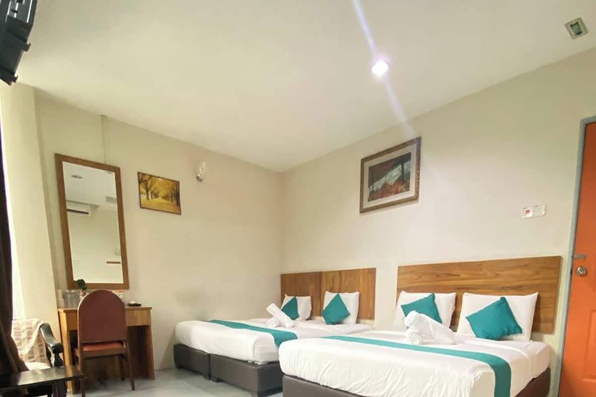 Quarto de hotel com duas camas, uma escrivaninha e uma cadeira.