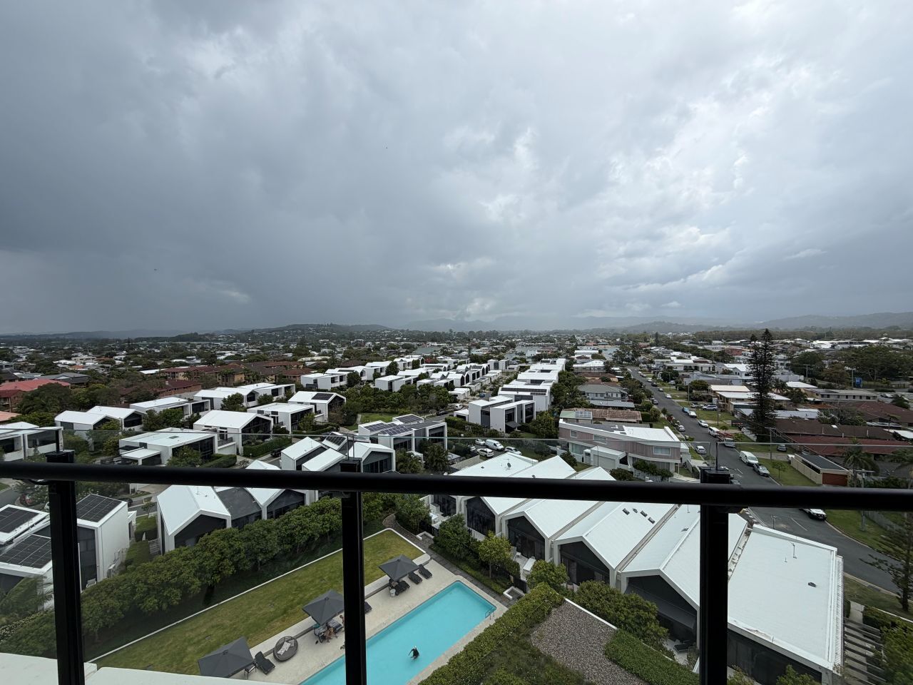 Zona residencial com casas modernas, piscina e vista do bairro ao redor.