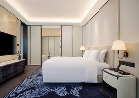 Quarto de hotel com cama grande, mesas de cabeceira, televisão de tela plana e design moderno.