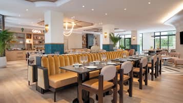 Um restaurante moderno com um espaço amplo para refeições, cabines e um bar.