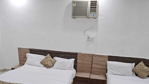 Quarto duplo com duas camas, cada uma com roupa de cama e almofadas estampadas.