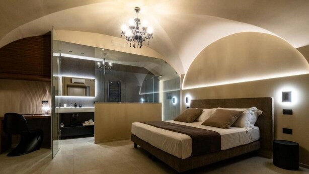 Um quarto moderno com uma cama grande, uma escrivaninha e um espelho.
