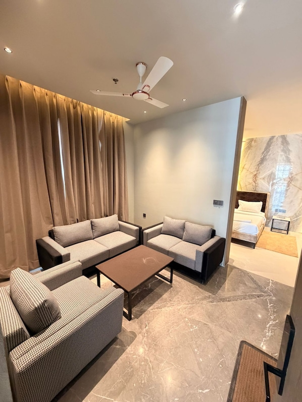 Uma sala de estar moderna com um sofá, uma mesa de centro e um ventilador de teto.