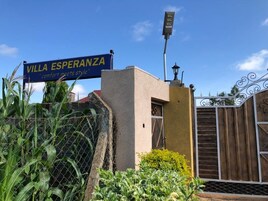 Uma entrada fechada com uma placa que diz "Villa Esperanza" e o slogan "conforto encontra estilo".