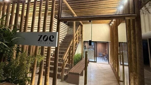 Entrada de um edifício moderno com uma placa que diz 'ZOO'.