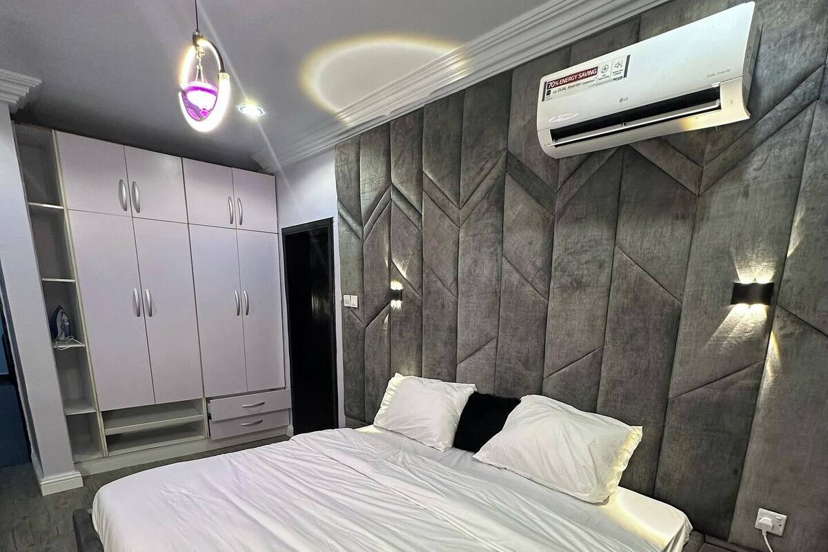 Quarto com cama grande, guarda-roupa embutido e ar condicionado.