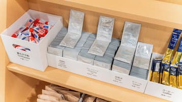 Uma prateleira com diversos produtos embalados, incluindo óleo de limpeza facial, pasta de dentes e café.