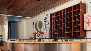 Um balcão de recepção com bancada de madeira e um suporte para vinhos acima.