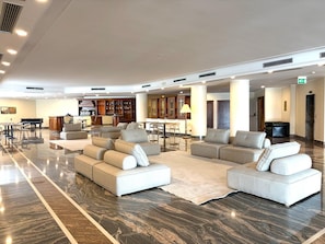Um lobby amplo com um piano de cauda, área de estar e bar.