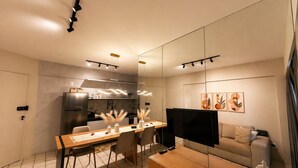 Uma cozinha moderna com área de refeições, um sof á e obras de arte na parede.
