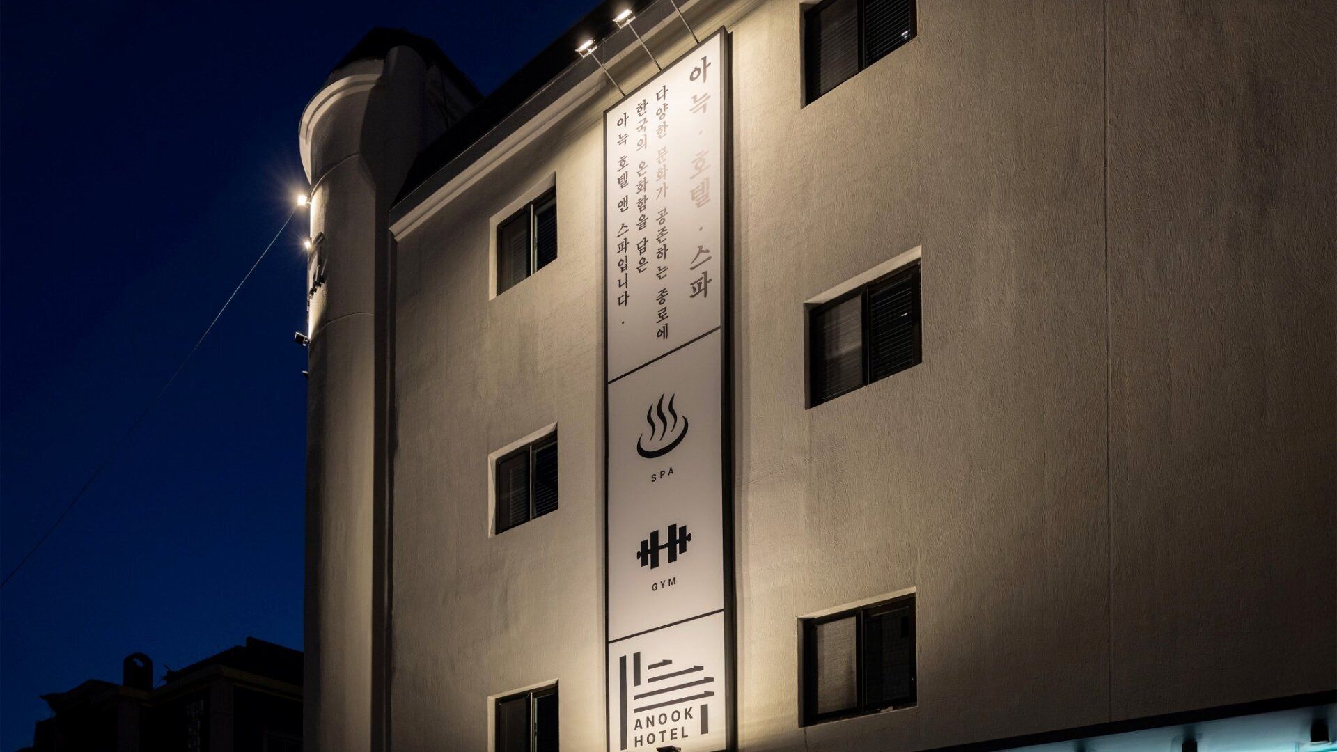 Um edifício com vários sinais indicando comodidades como academia, spa e hotel.