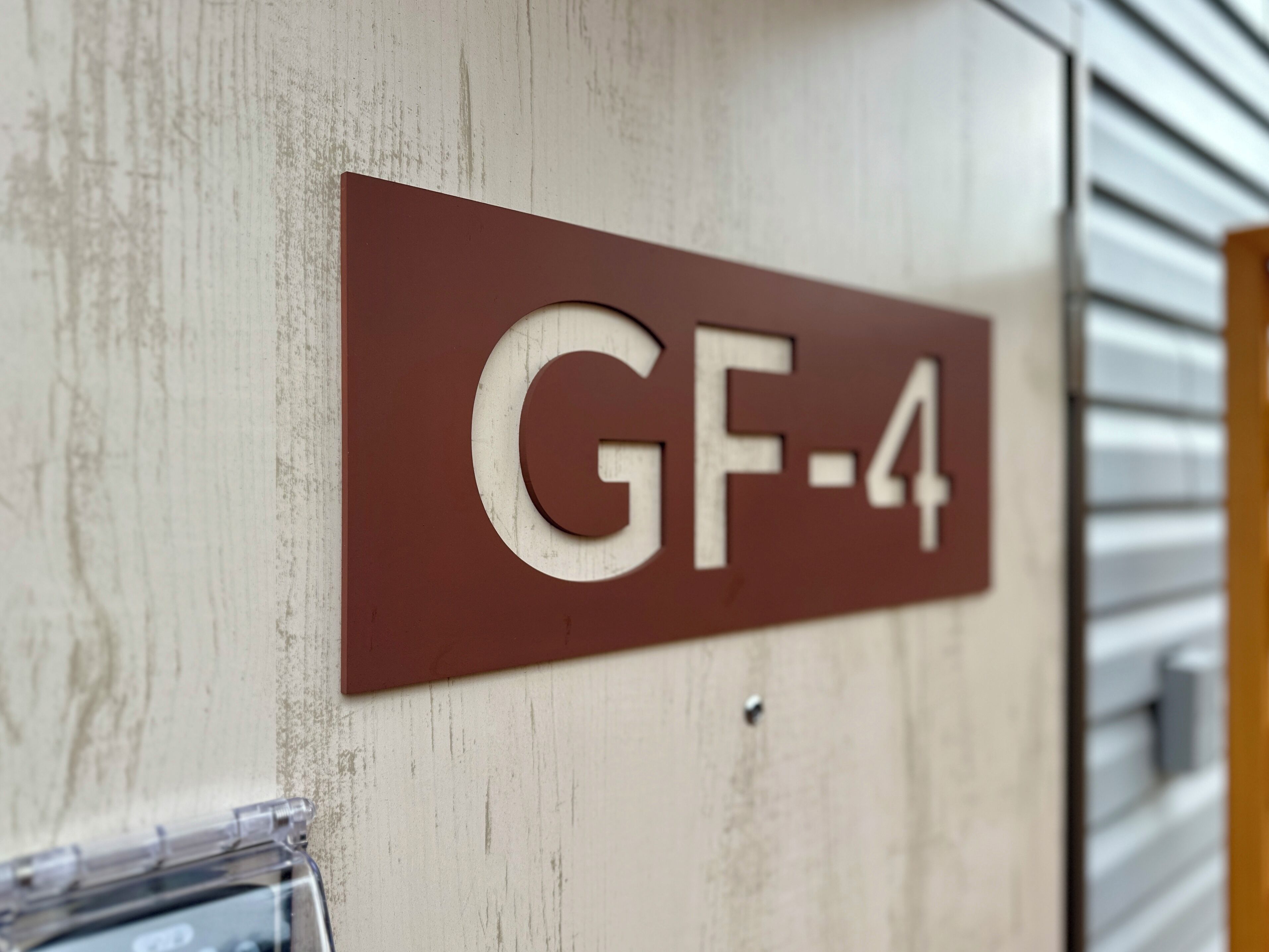 Um sinal com a inscrição 'GF-4' numa parede de madeira.
