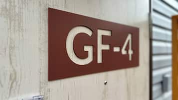 Um sinal com a inscrição 'GF-4' numa parede de madeira.