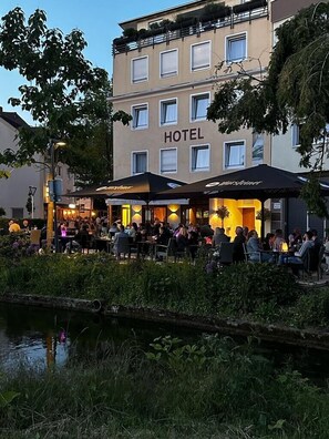 Hotel com área de estar ao ar livre e um canal em frente.