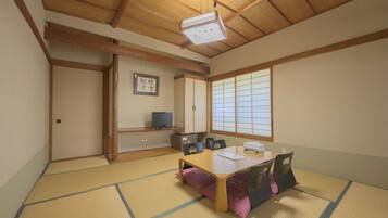 Um quarto japonês tradicional com piso de tatame, uma mesa de madeira baixa e portas deslizantes.