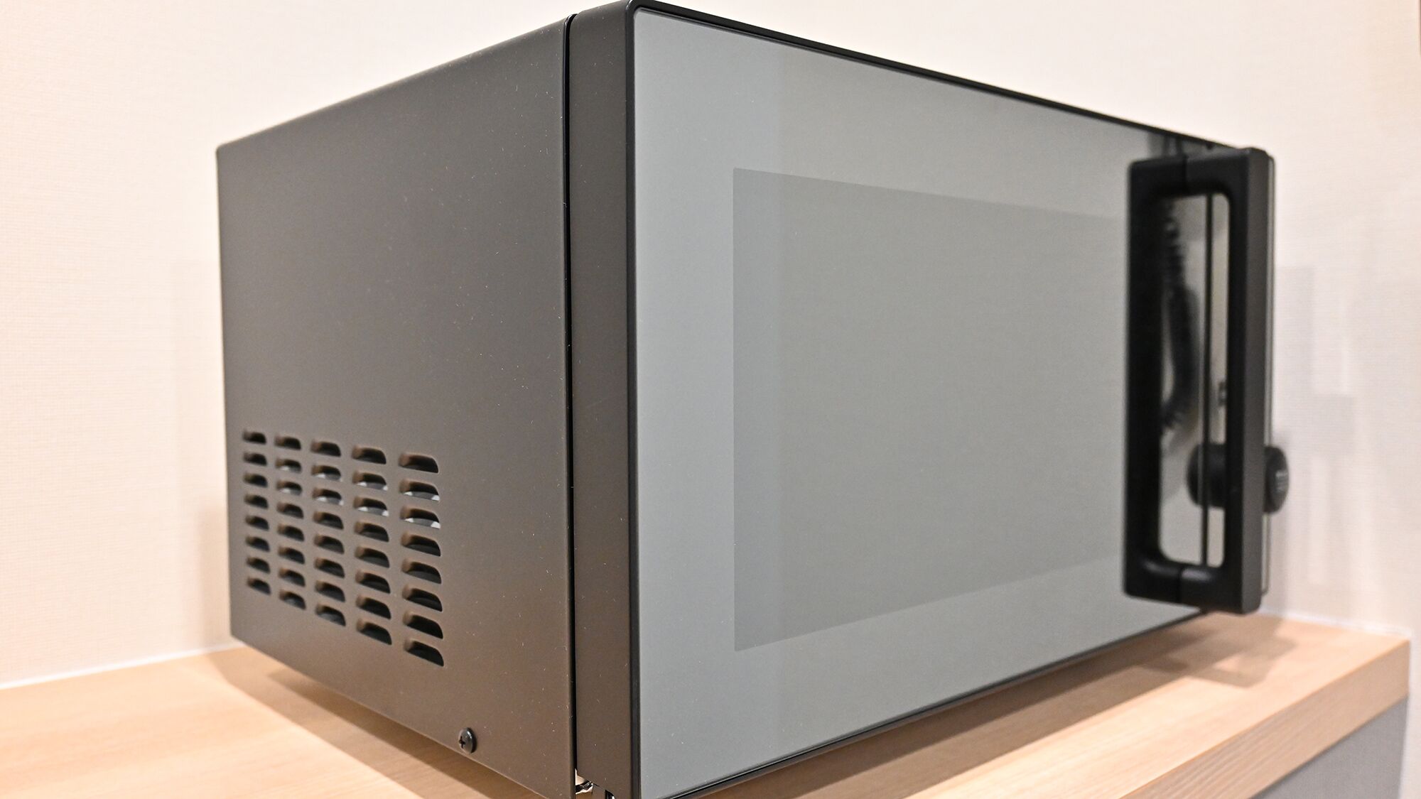 Um computador desktop moderno e compacto, com design elegante, apresentando um sistema de ventilação no lado esquerdo e um monitor grande à direita.