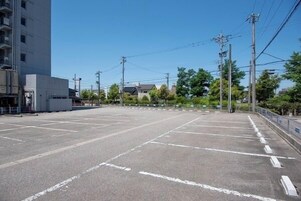 Um estacionamento com vagas demarcadas e um edifício ao fundo.