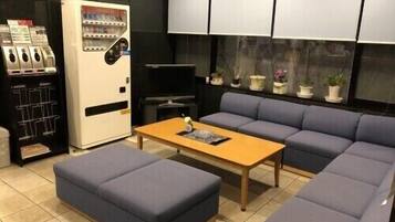 Uma sala de estar moderna com um sofá seccional, uma mesa de centro e uma máquina de vendas.