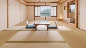 Um quarto japonês tradicional com piso de tatame, uma mesa baixa e portas deslizantes.