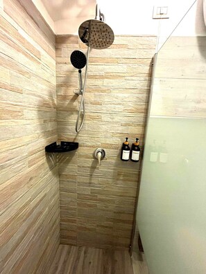 Quarto quádruplo luxo | Banheiro | Chuveiro, secador de cabelo, toalhas de banho, sabonete