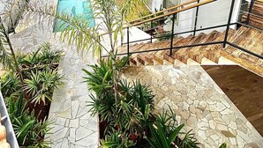 Um imóvel residencial com piscina, escadaria que dá para uma varanda e vista do bairro ao redor.