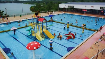 Piscina com várias pistas de natação, toboáguas e posto de salva-vidas.