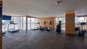 Uma academia com esteiras, elípticos e bolas de exercício.