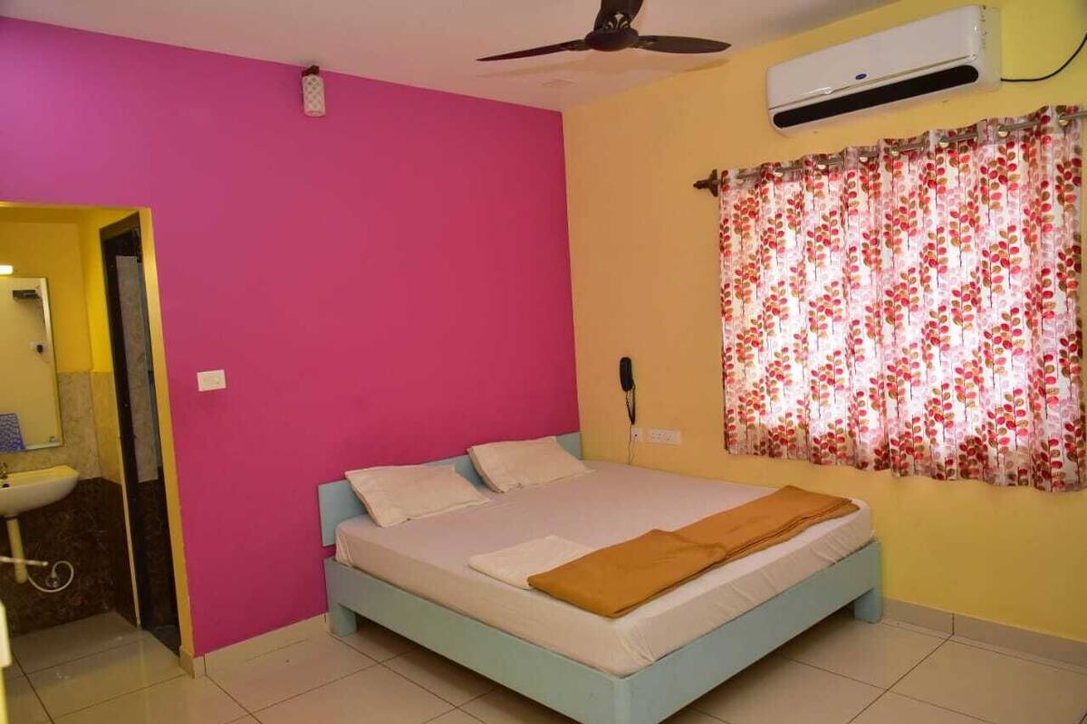 Quarto com cama, ventilador de teto e ar condicionado.