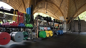 Academia coberta com equipamentos de musculação e barras.