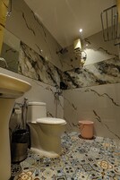 Uma casa de banho com sanita, lavatório e zona de duche.