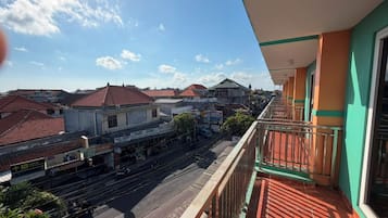 Uma varanda com vista para a rua e prédios.