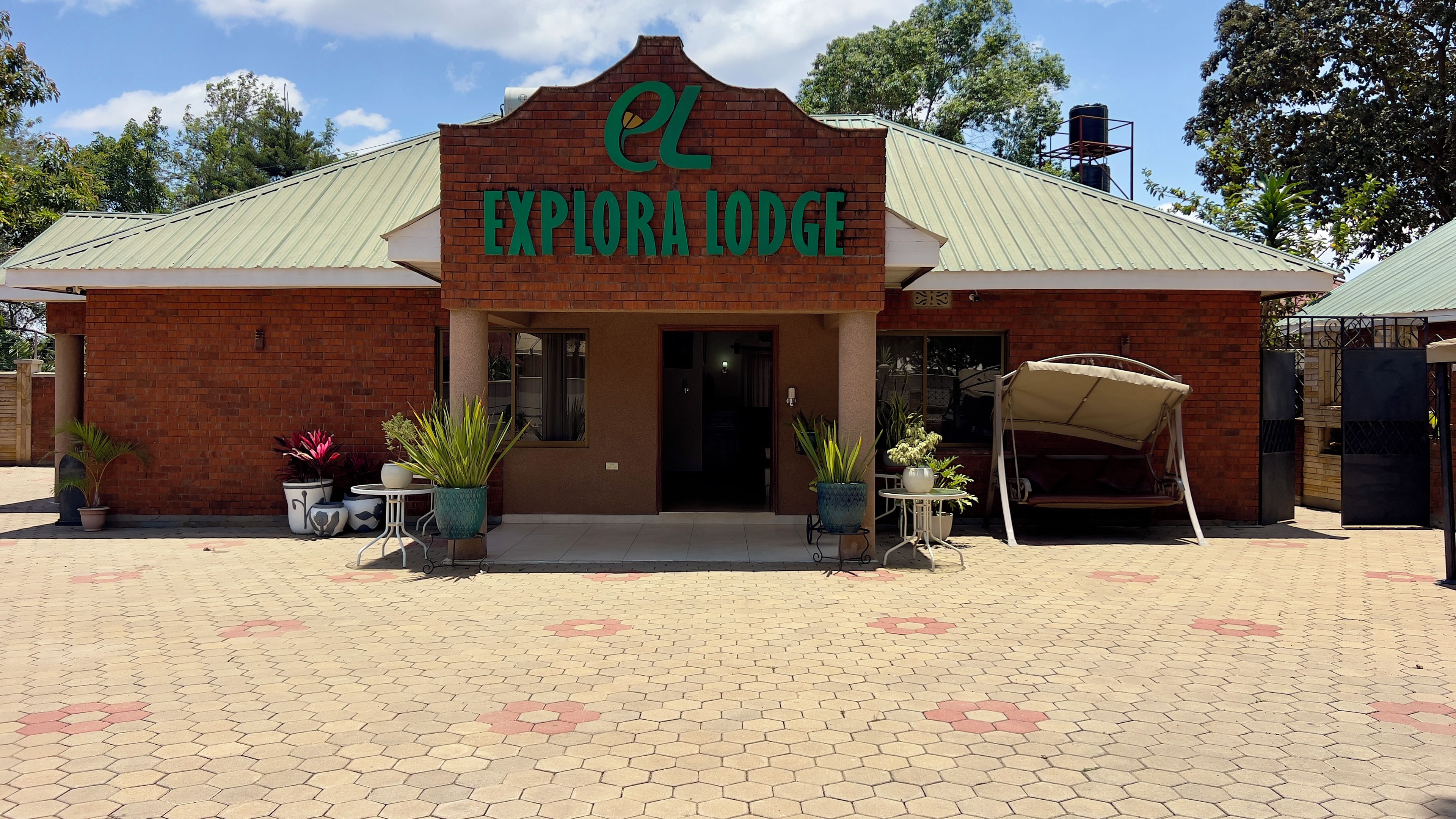 Um edifício de tijolos com telhado verde e a placa 'EXPLORA LODGE'.